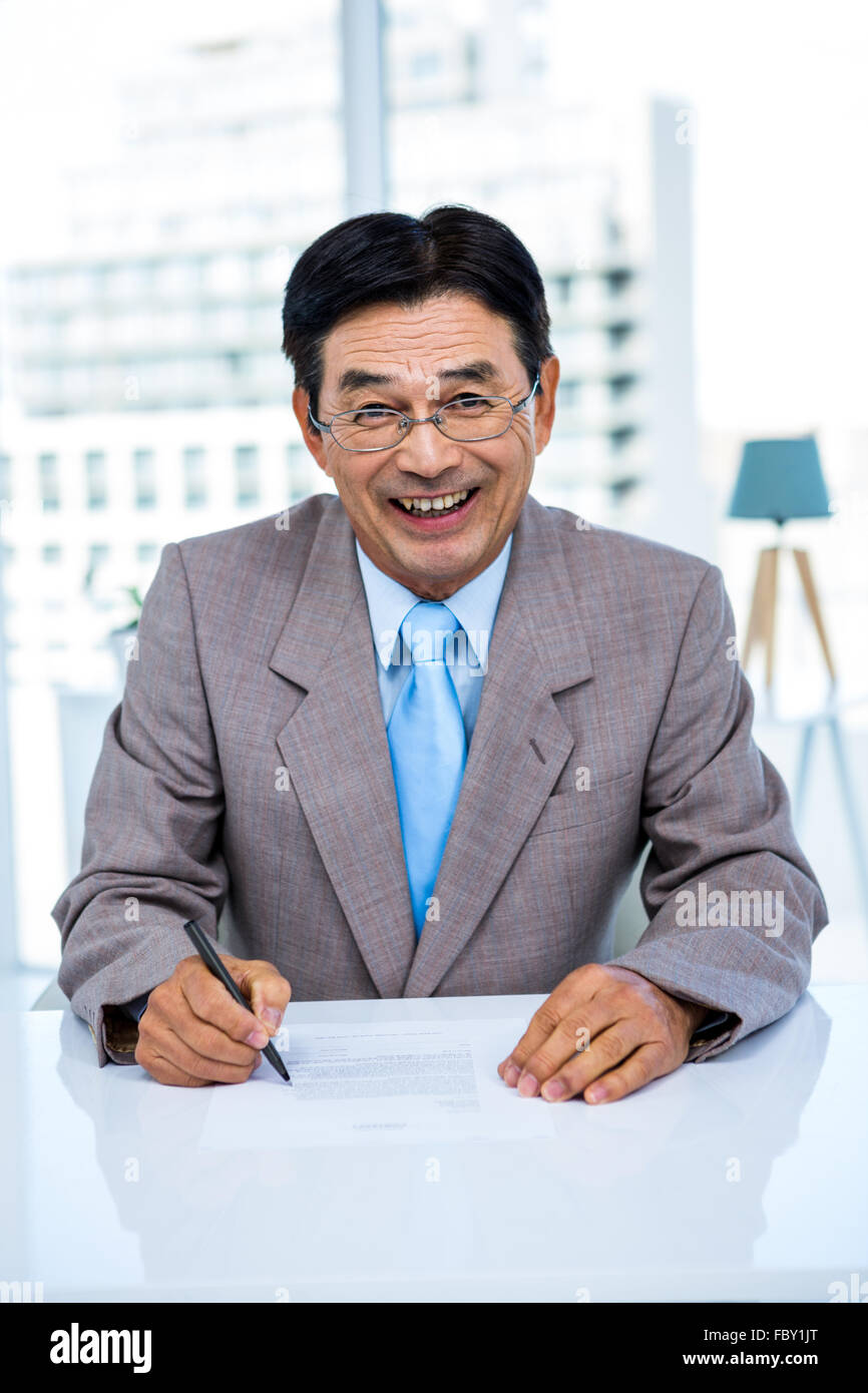 Happy businessman on his desk Stock Photo - Alamy