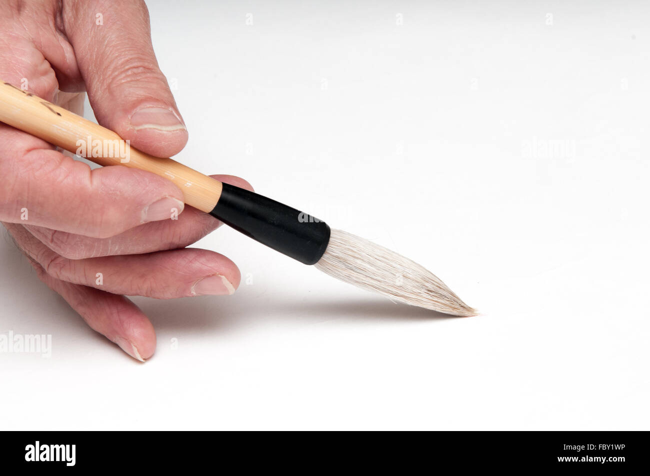 Man holding a calligraphy brush with space to add text Stock Photo - Alamy