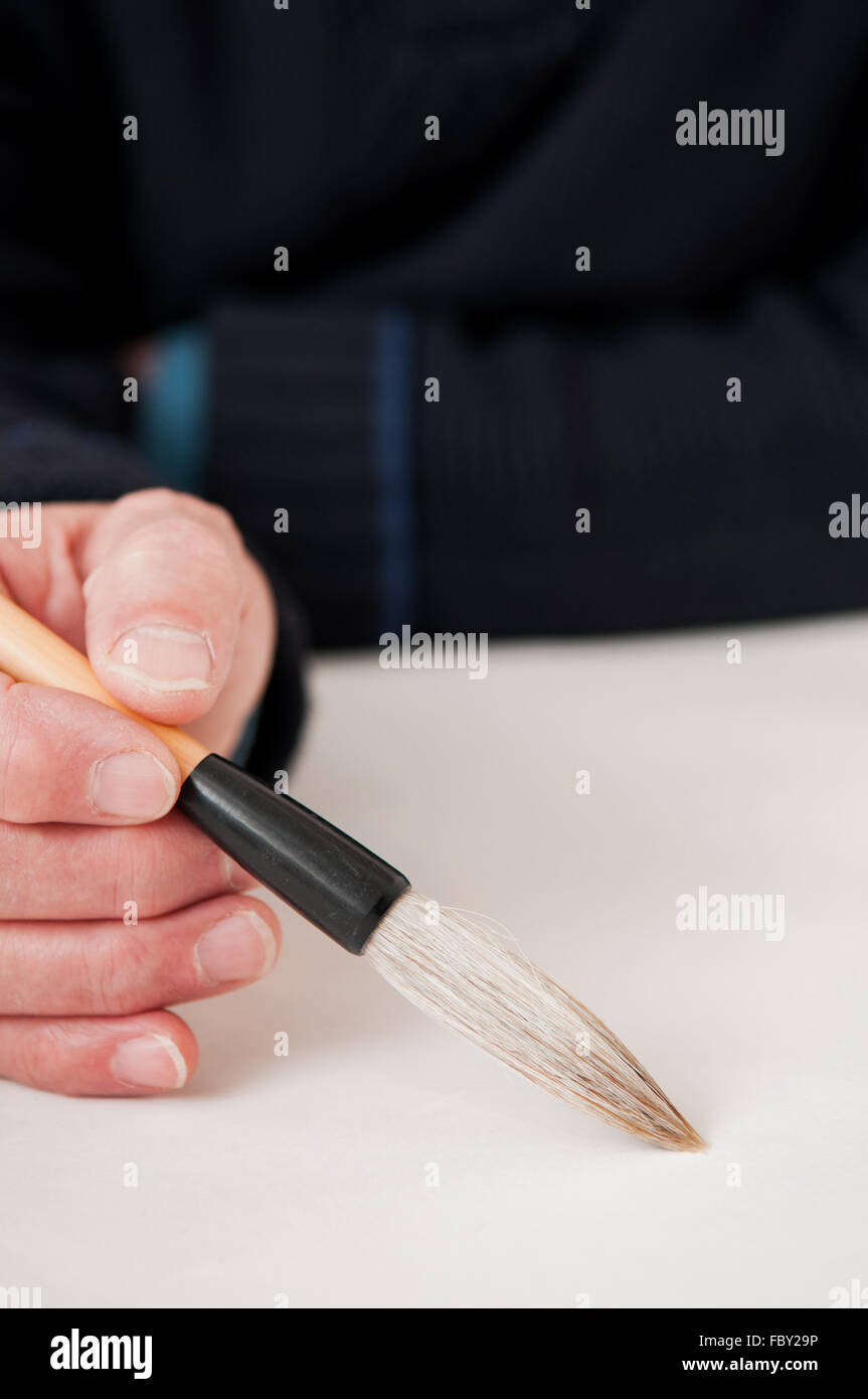 Man holding a calligraphy brush with space to add text Stock Photo - Alamy