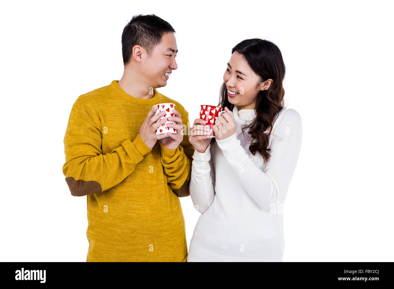 Happy young couple looking at each other while holding cups Stock Photo ...