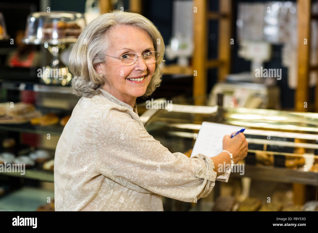 Smiling senior woman checking list Stock Photo - Alamy