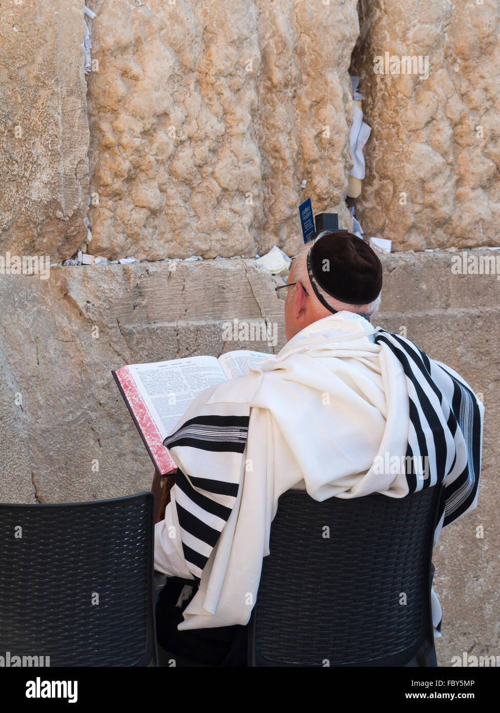 Old Jewish man in traditional costume reading the Torah by the Western ...