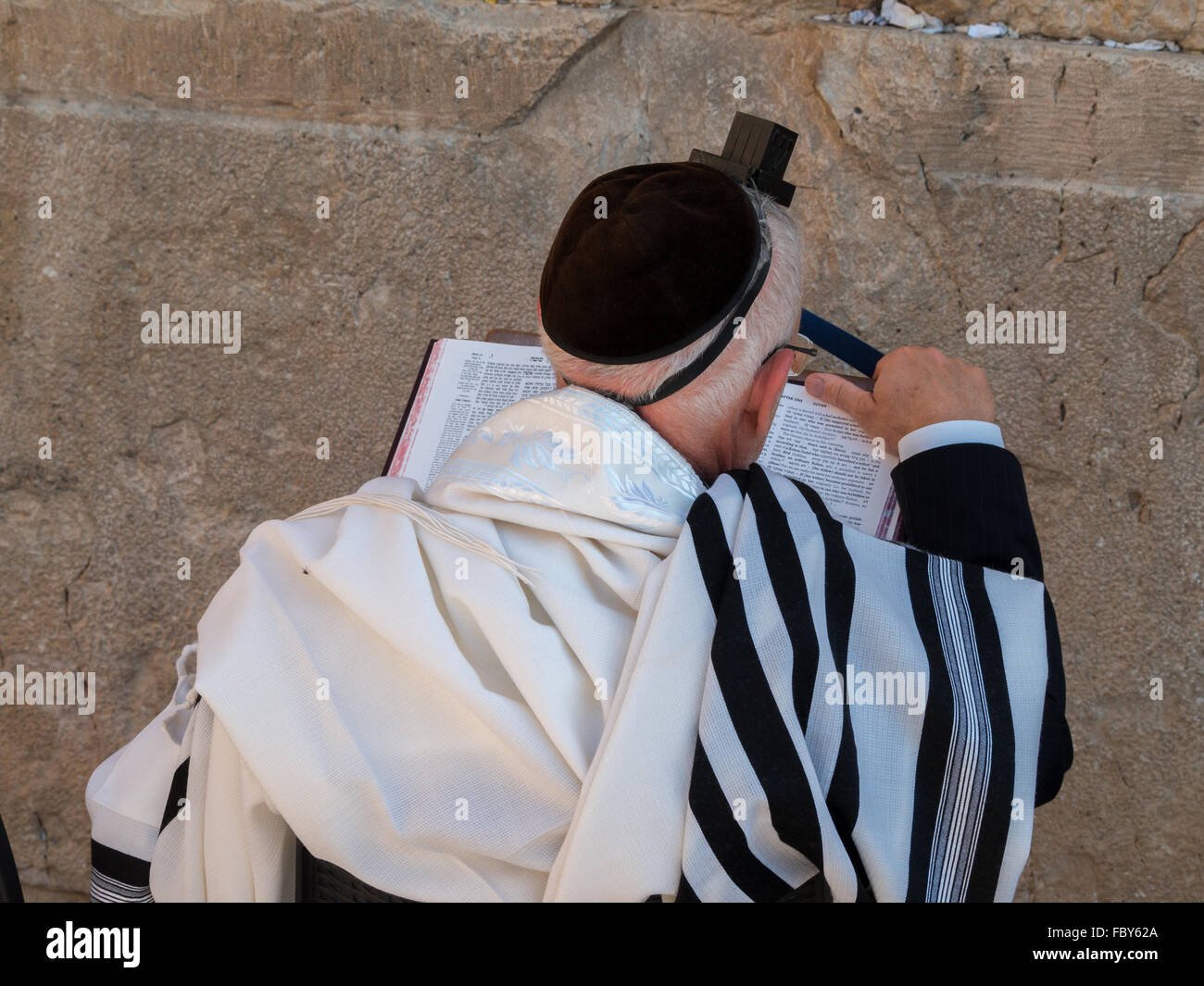 Old Jewish man in traditional costume reading the Torah by the Western ...