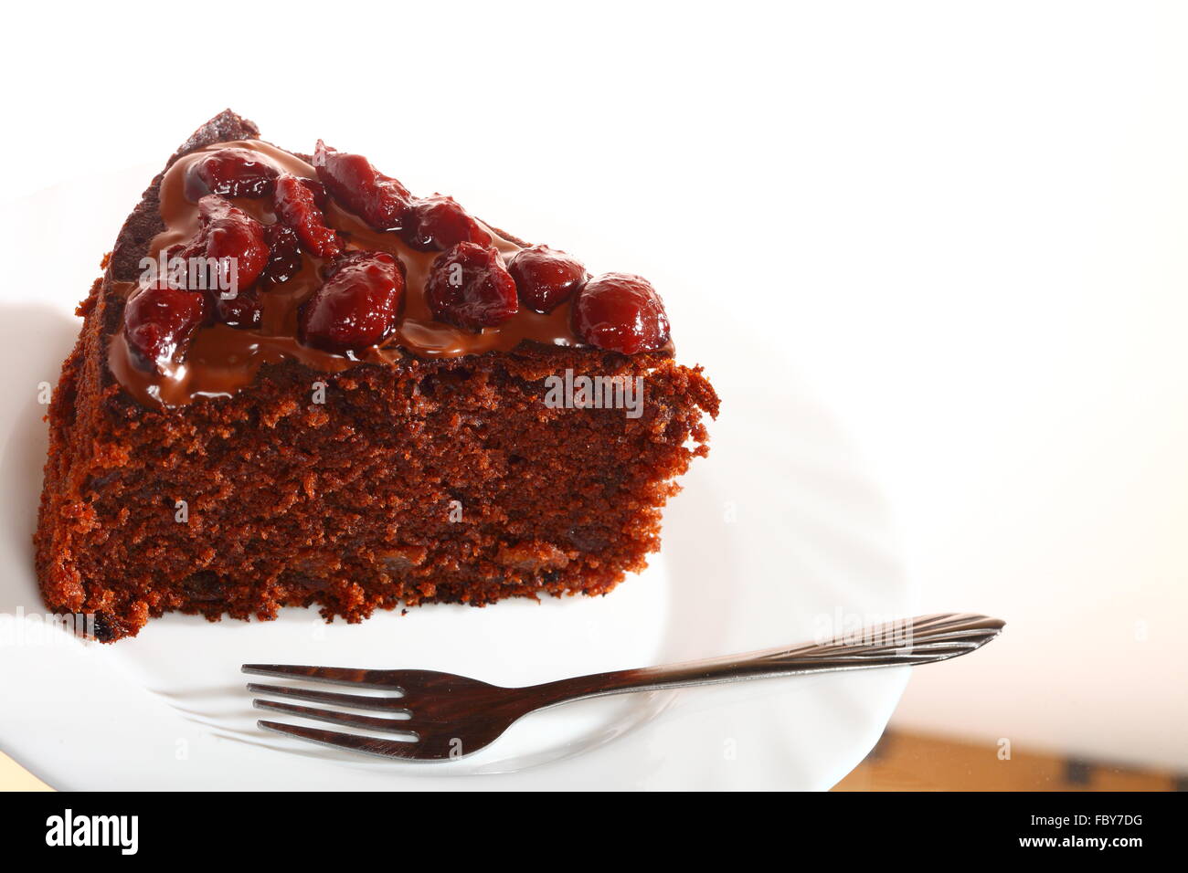Piece of chocolate cake with icing and cherry Stock Photo - Alamy