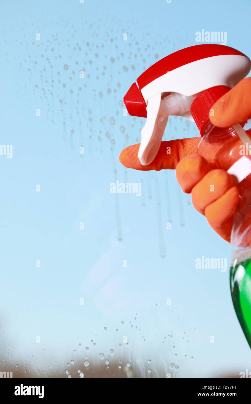 Gloved hand cleaning window rag and spray Stock Photo - Alamy