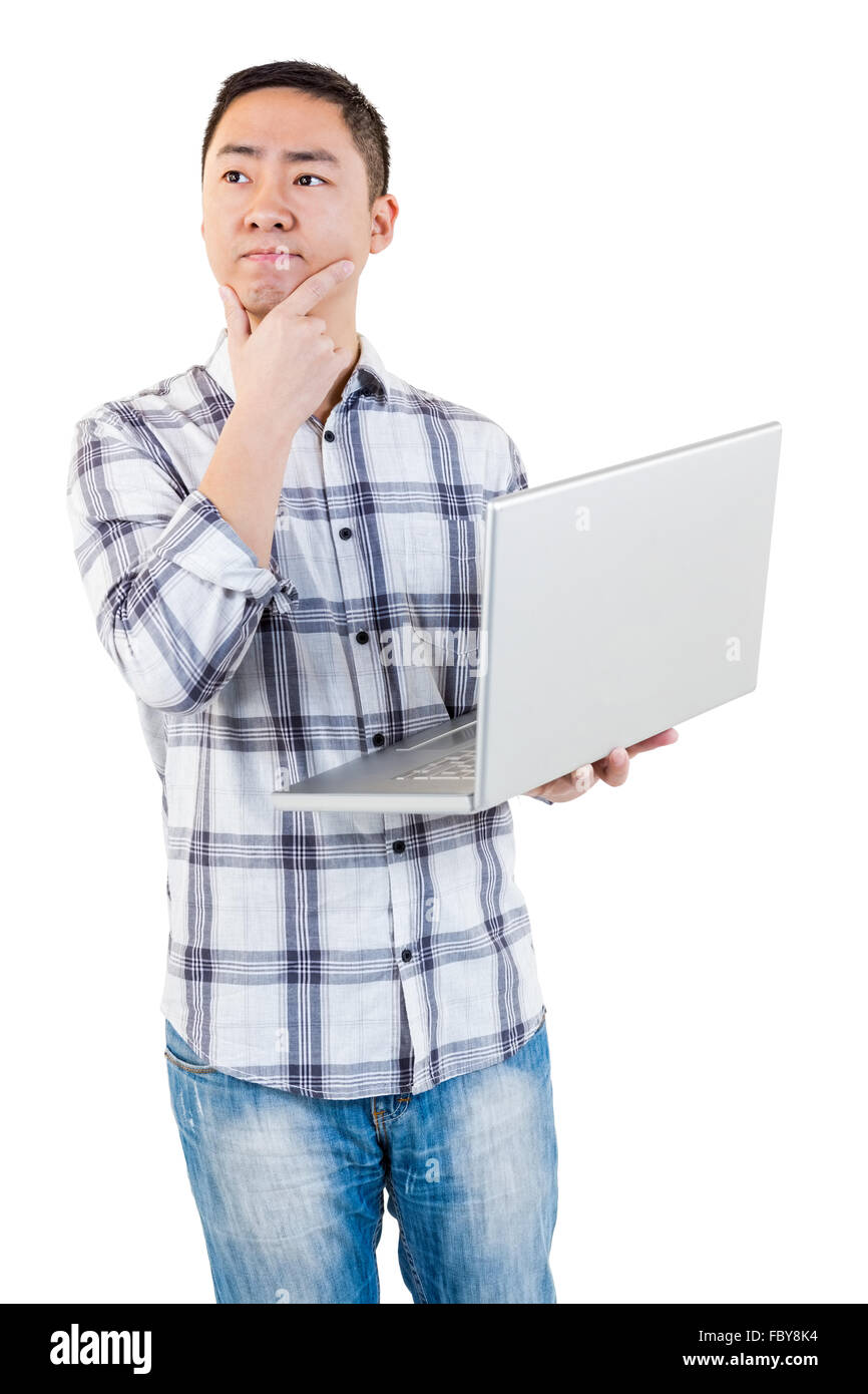 Thoughtful man holding laptop Stock Photo - Alamy