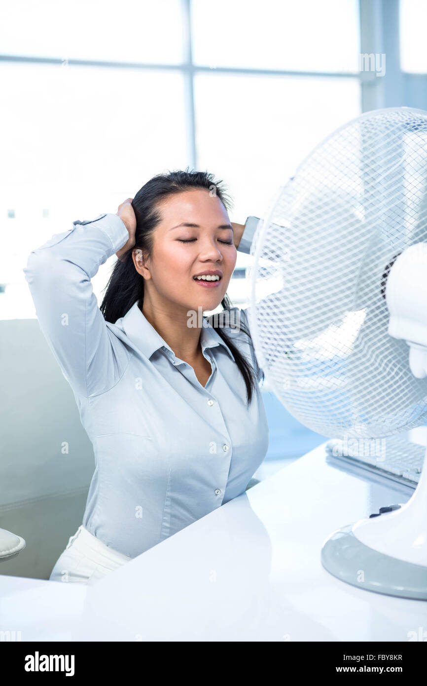 Businesswoman sitting in front of fan Stock Photo - Alamy