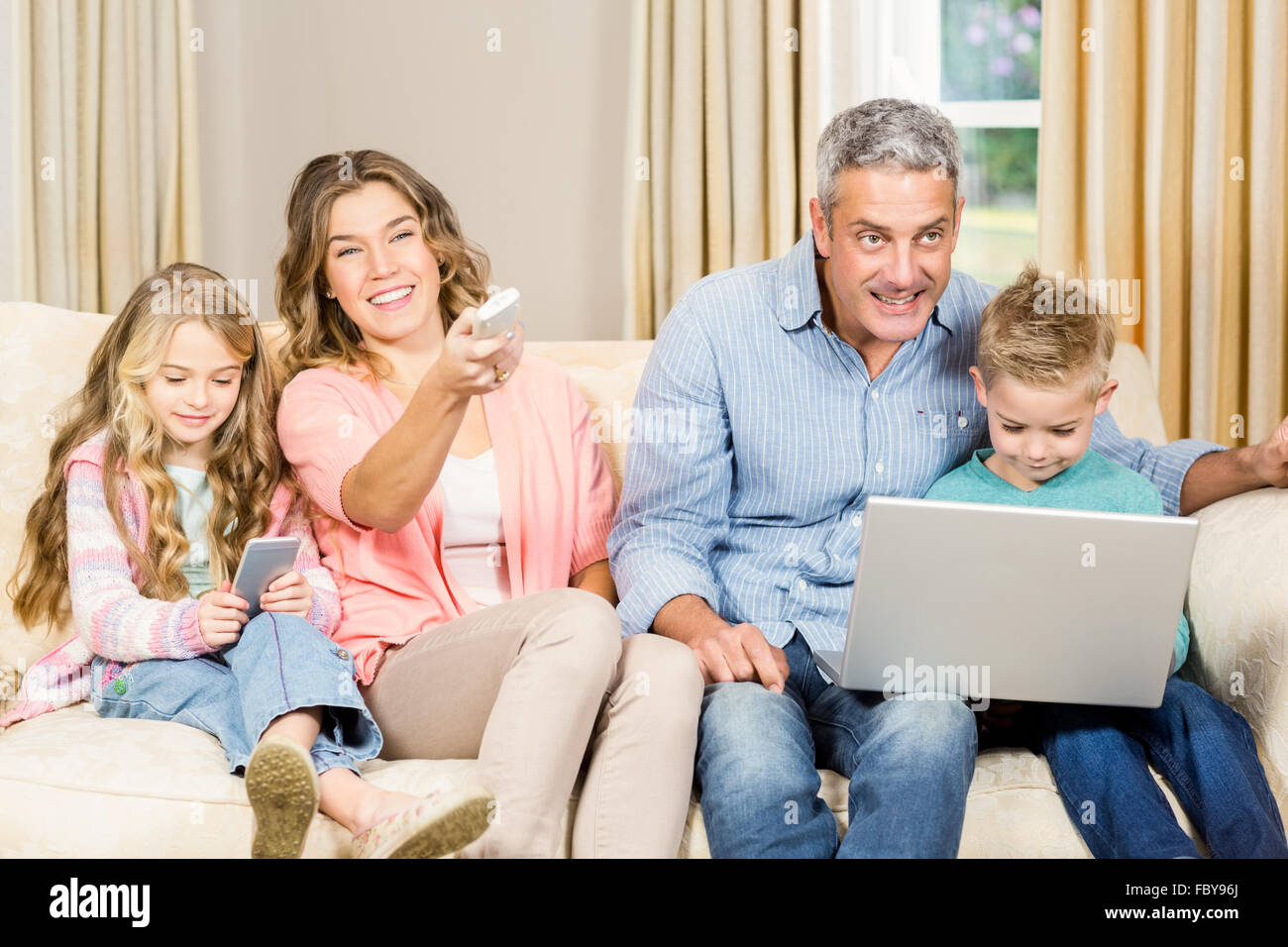 Happy family sitting at home Stock Photo - Alamy