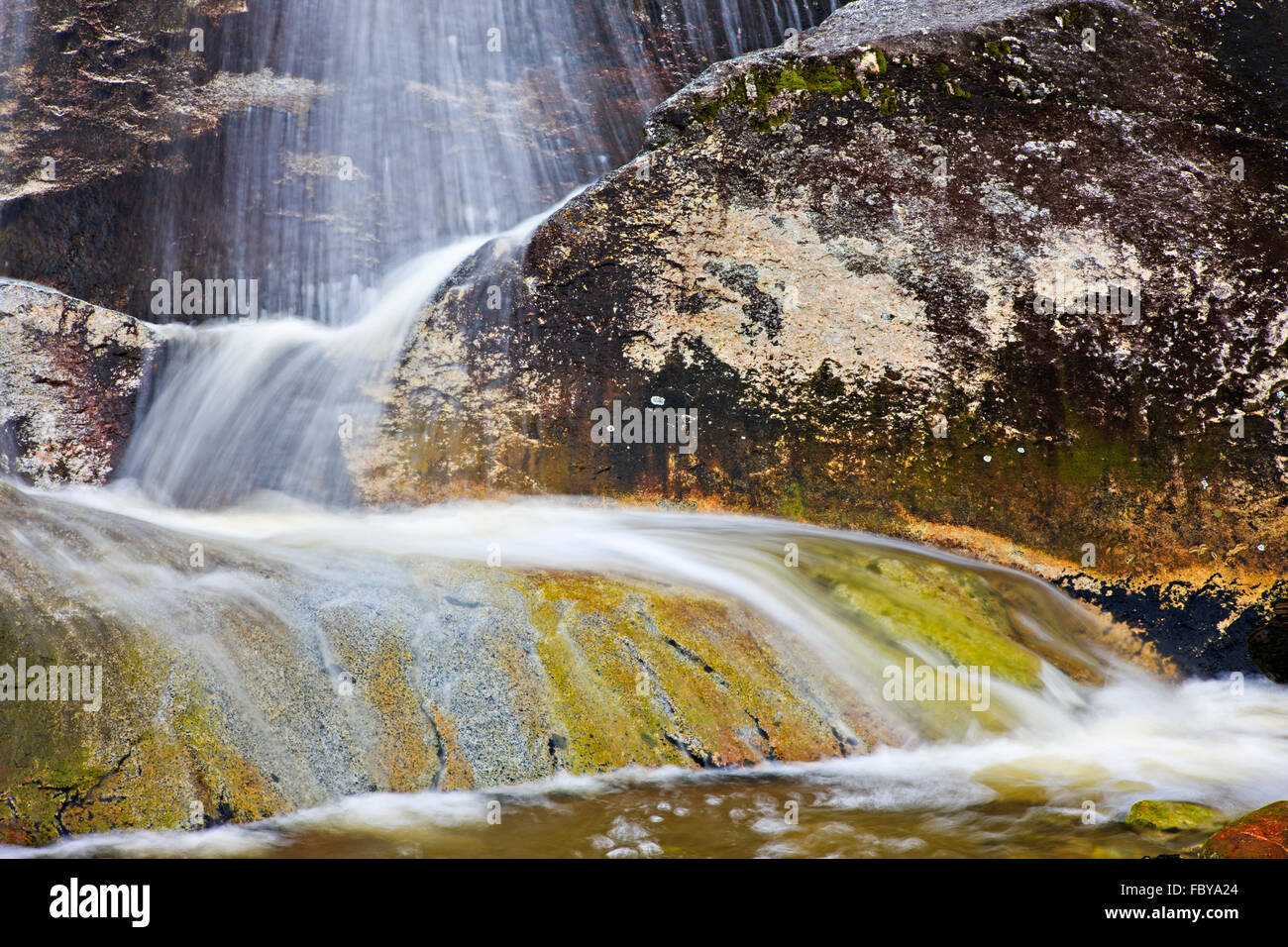 Noname waterfall running down on the hard rock of a mountain right into ...