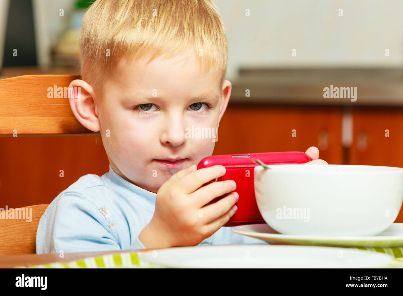 boy kid child eating corn flakes breakfast playing mobile phone Stock ...