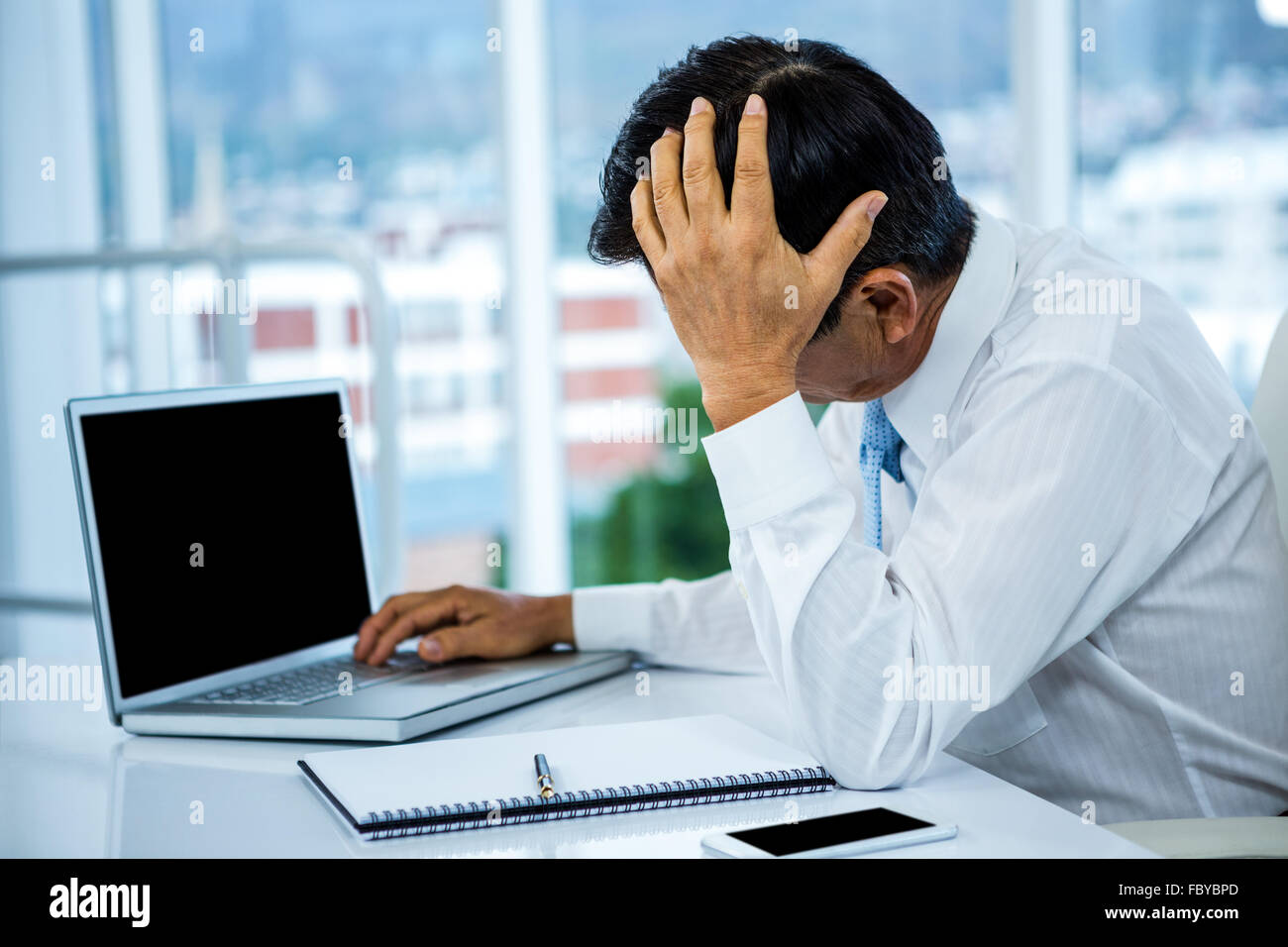 Worried businessman working at his desk Stock Photo - Alamy