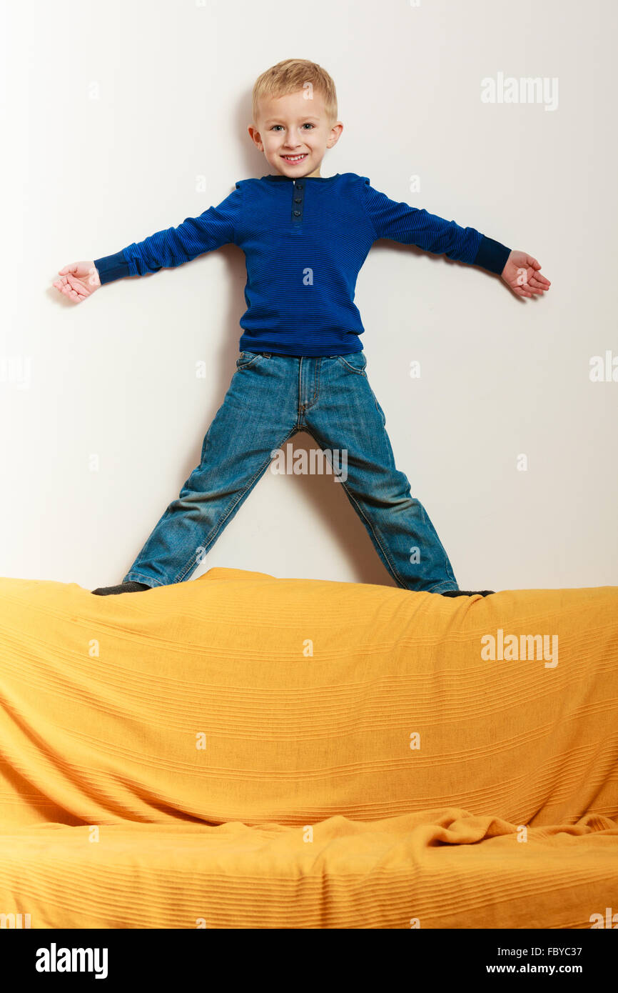 Boy child kid preschooler standing on back rest of sofa interior Stock ...