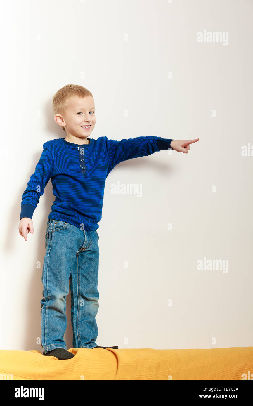 Boy child kid preschooler standing on back rest of sofa interior Stock ...