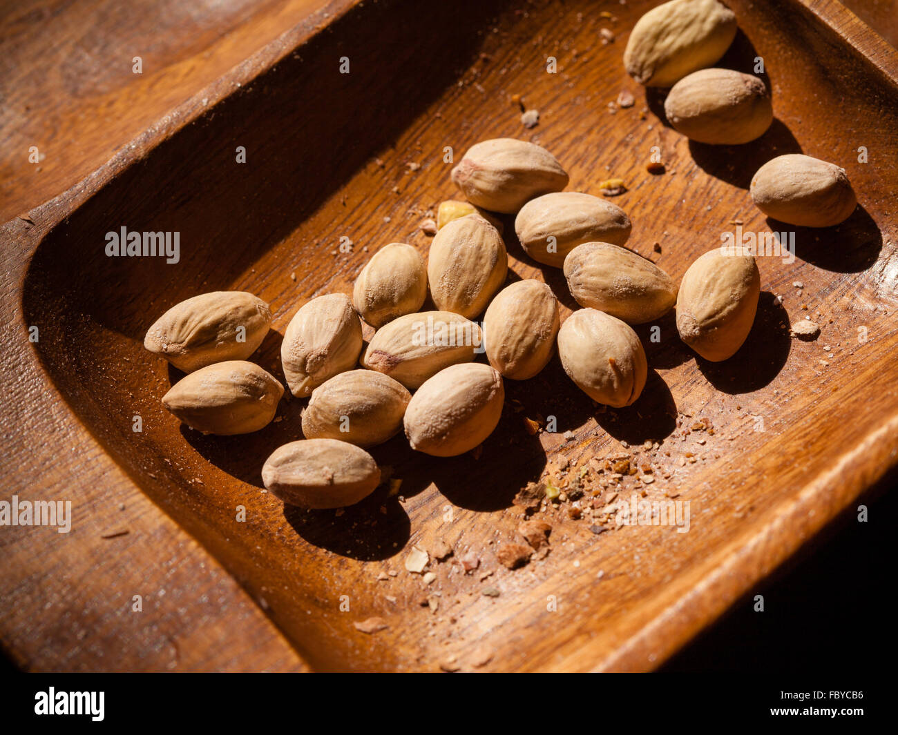 Pistachios nuts in wooden bowl. Unhealthy food Stock Photo - Alamy
