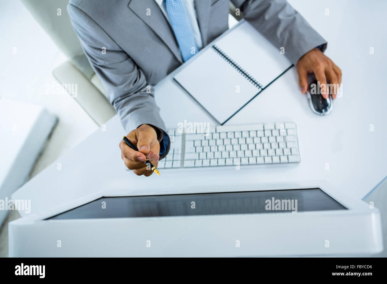 Businessman pointing at computer monitor Stock Photo - Alamy