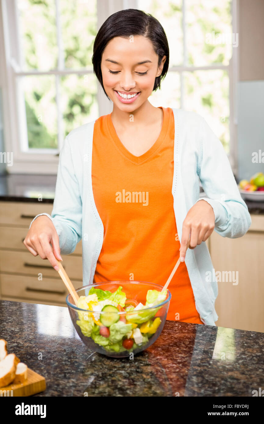 Smiling brunette preparing salad Stock Photo - Alamy