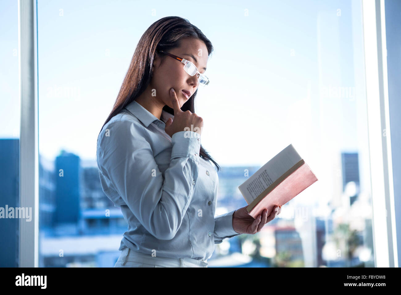Concentrated businesswoman reading book Stock Photo - Alamy