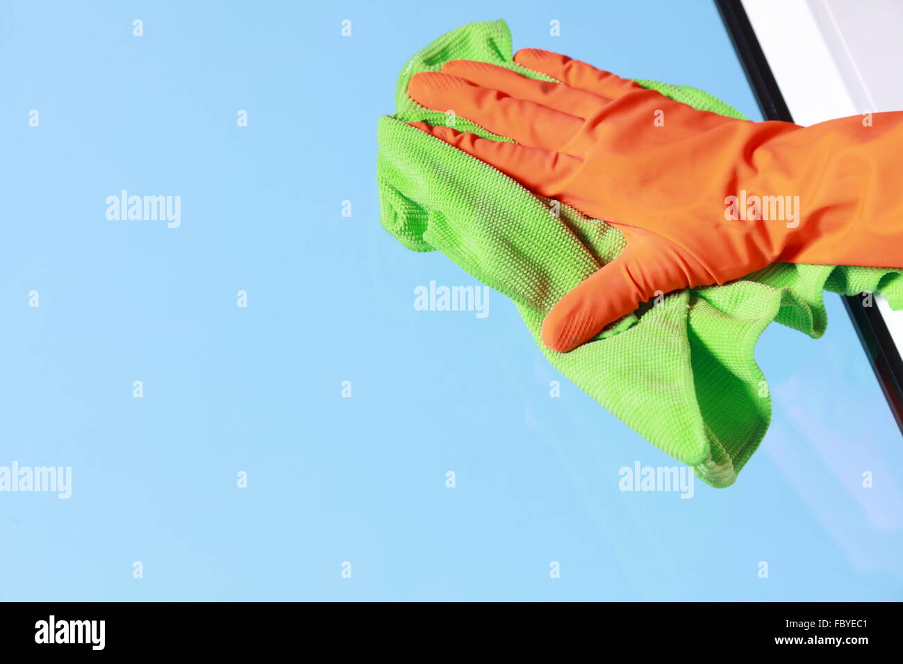 Gloved hand cleaning window with rag Stock Photo - Alamy