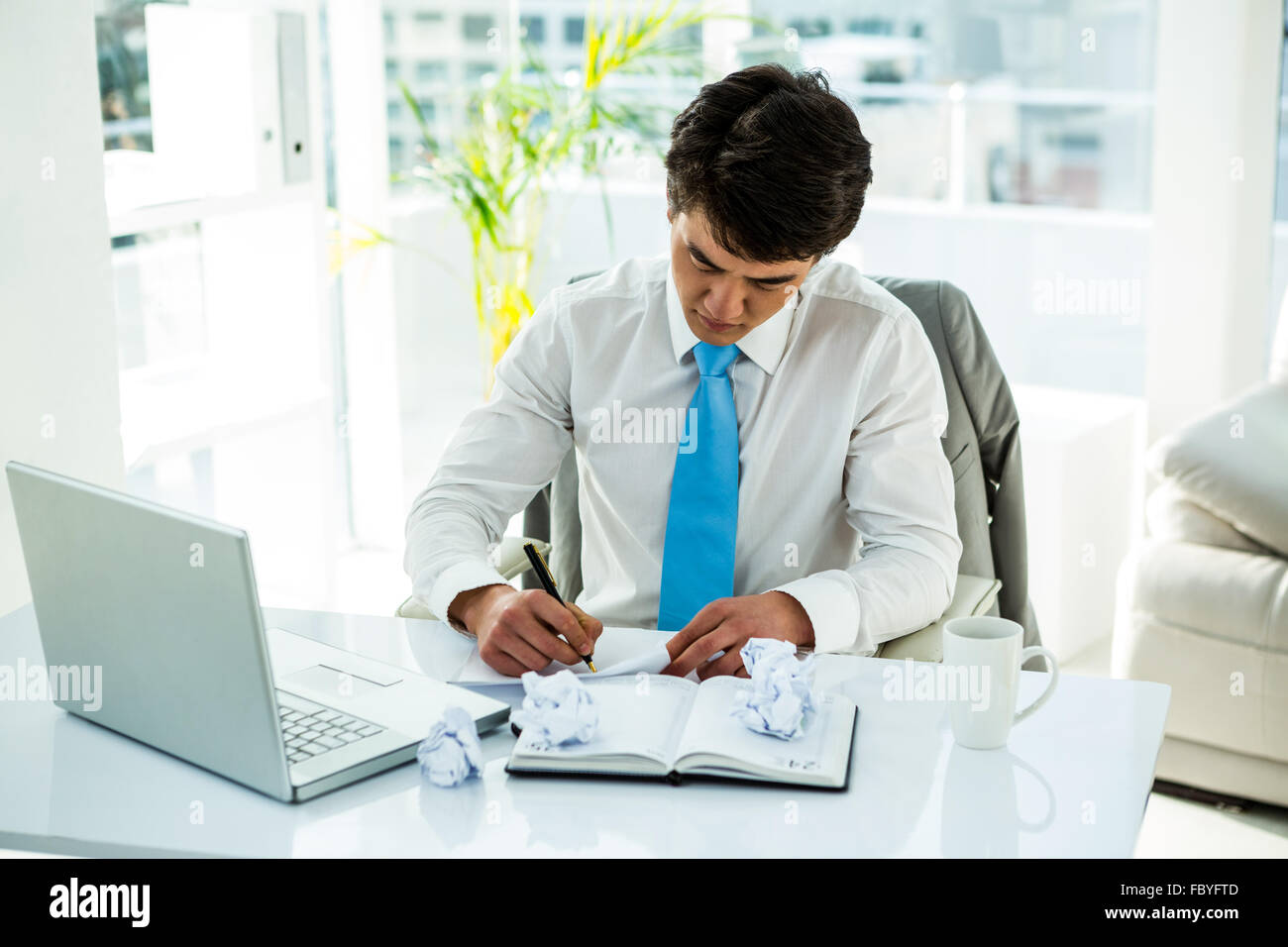 Busy asian businessman writing Stock Photo - Alamy