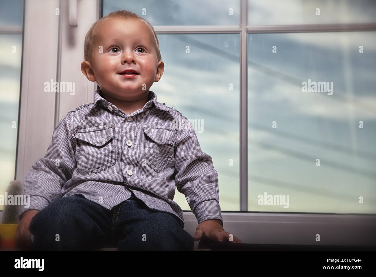 little boy sitting on window Stock Photo - Alamy