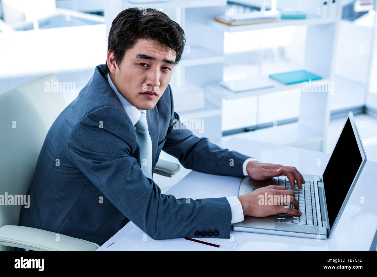Tired businessman using his computer Stock Photo - Alamy