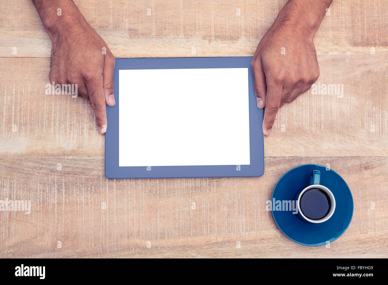 Hand holding on digital tablet over table by coffee Stock Photo - Alamy