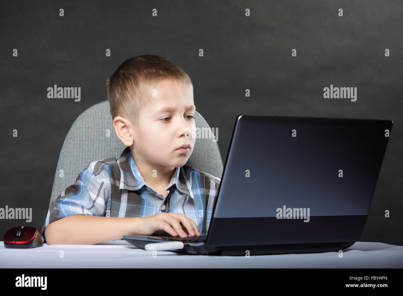 Computer addiction child with laptop notebook Stock Photo - Alamy