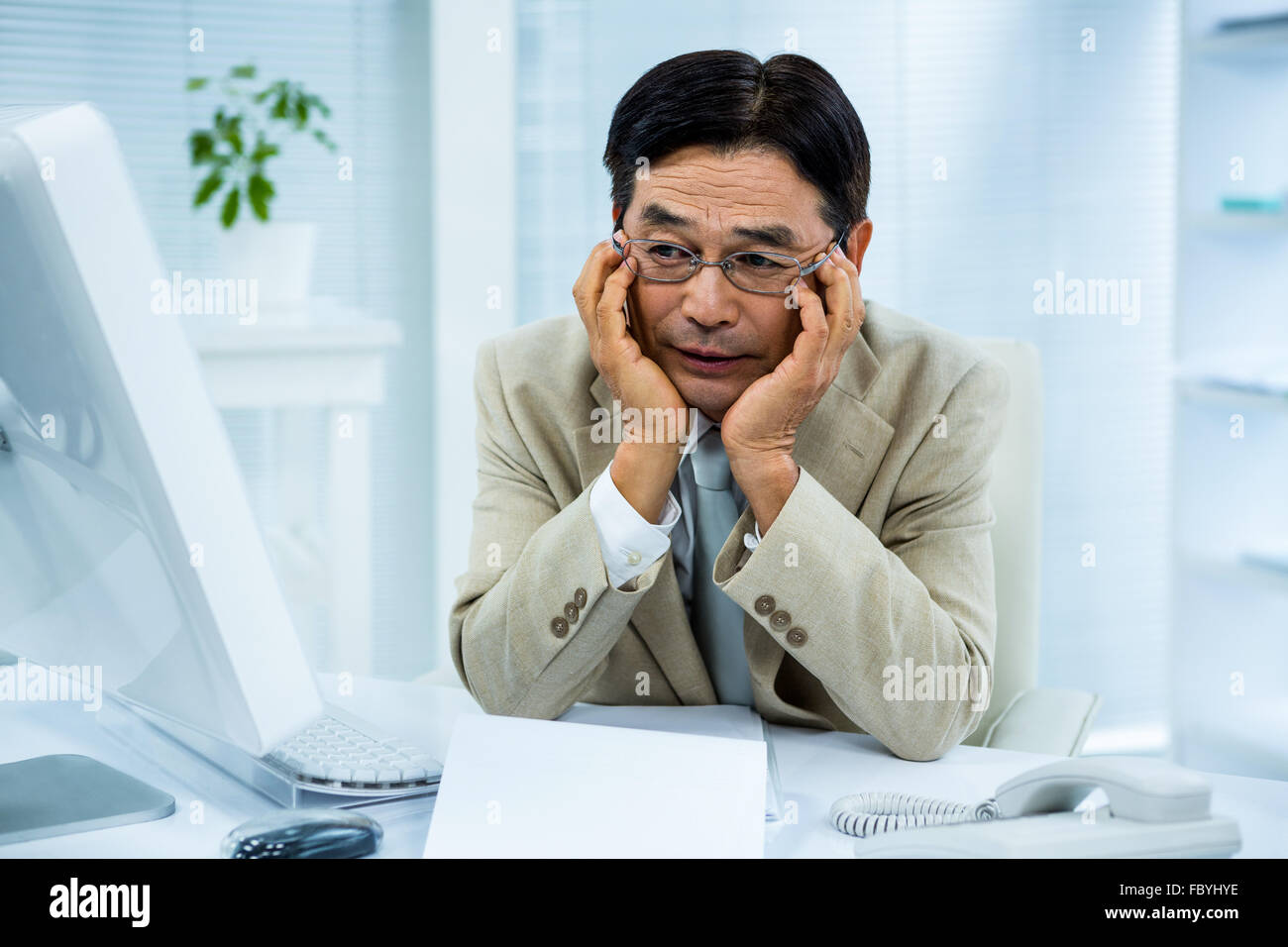 Tired businessman holding his head Stock Photo - Alamy
