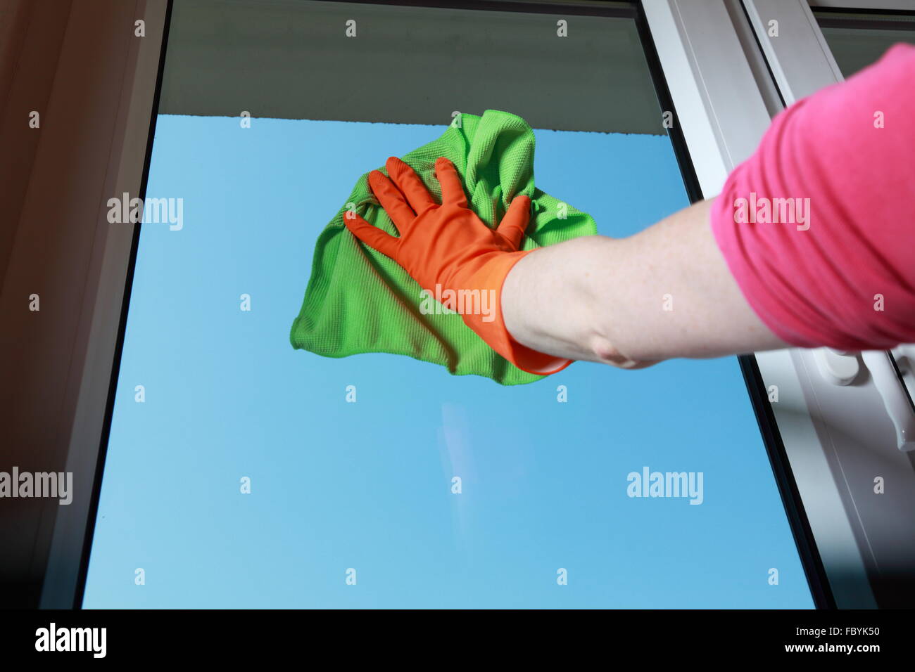 Gloved hand cleaning window with rag Stock Photo - Alamy