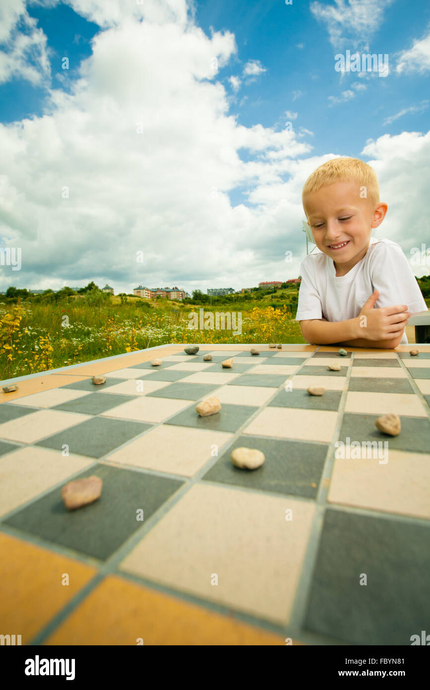 Child playing draughts or checkers board game outdoor Stock Photo - Alamy