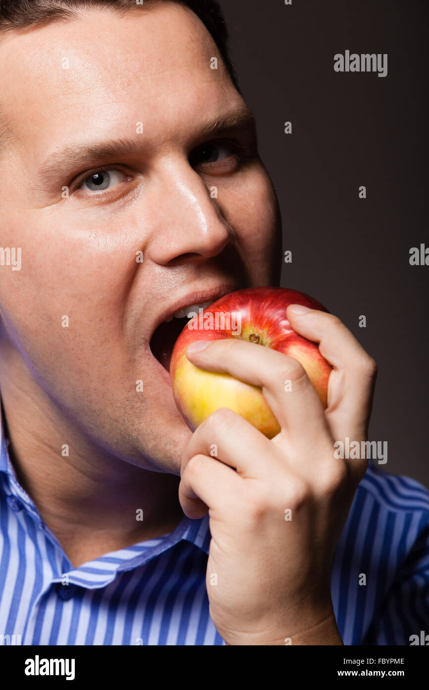 Diet nutrition. Happy man biting apple fruit Stock Photo - Alamy