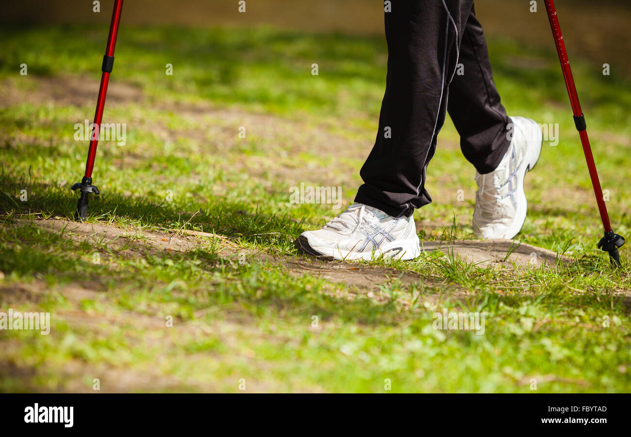Nordic walking. Female legs hiking in the park Stock Photo - Alamy