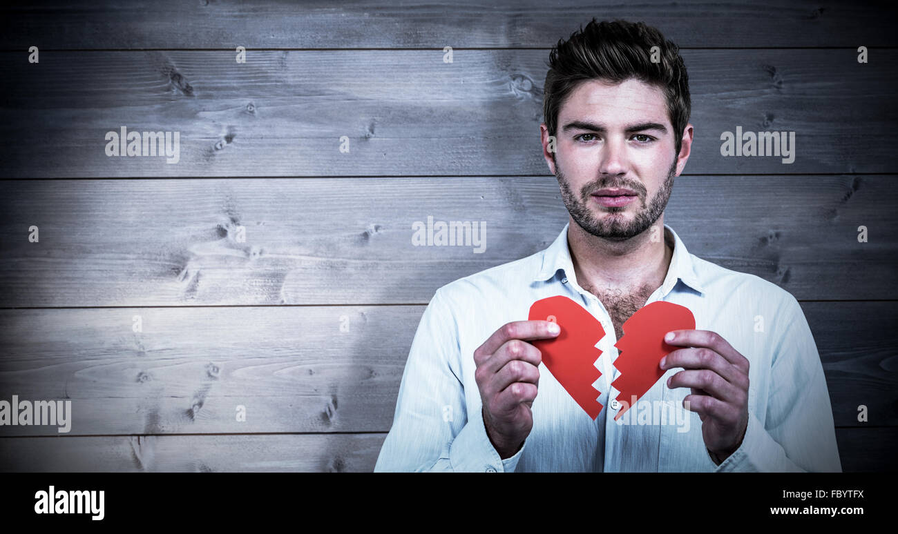 Composite image of sad man holding heart halves Stock Photo - Alamy