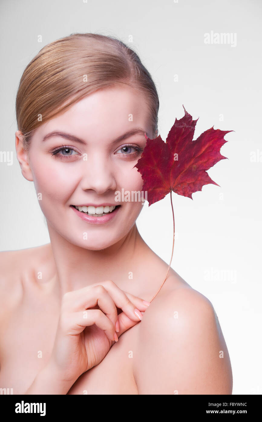 Skin care. Portrait of young woman girl with red maple leaf Stock Photo ...