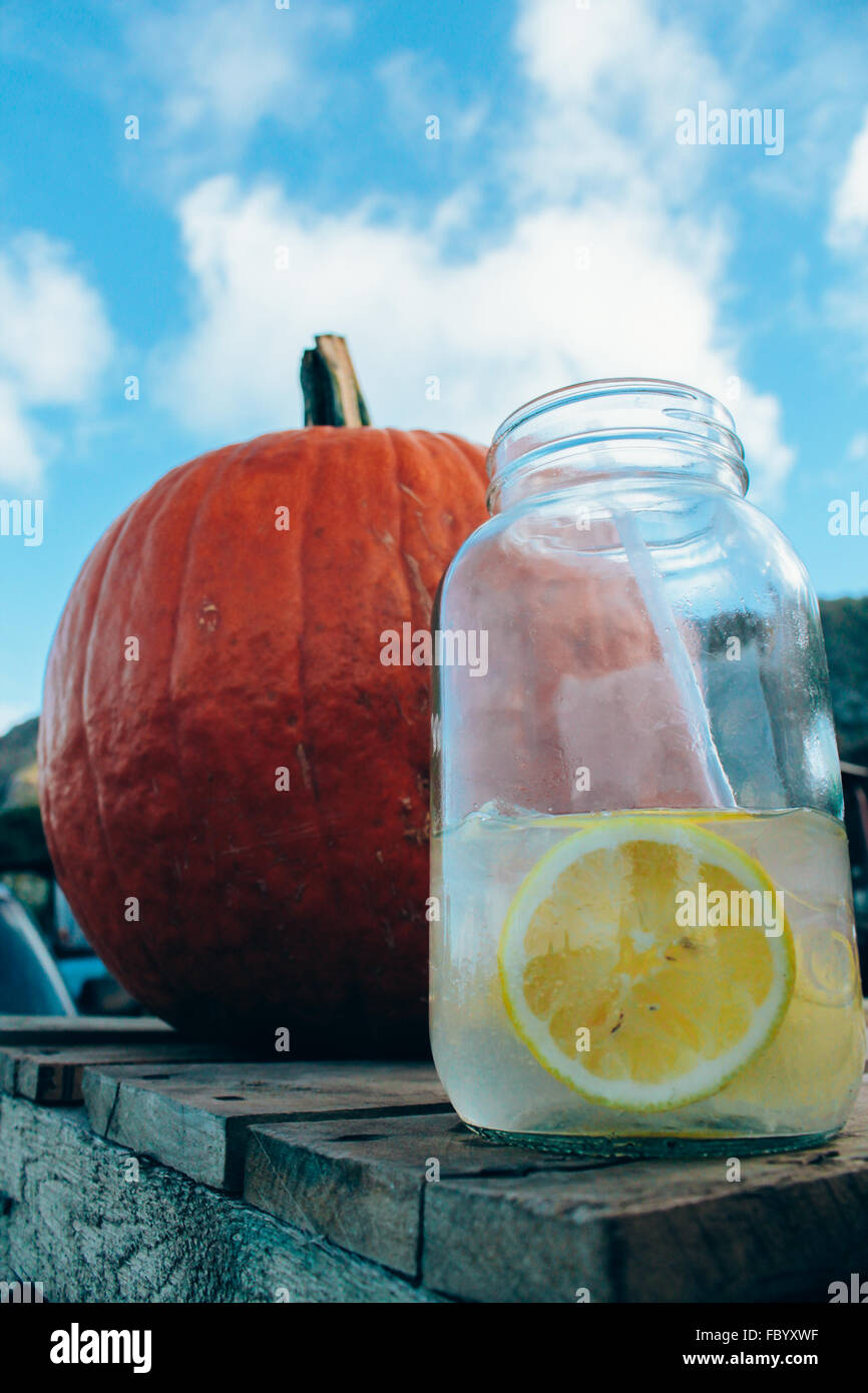 pumpkin and ice cold lemonade in a jar with large lemon slice and straw ...
