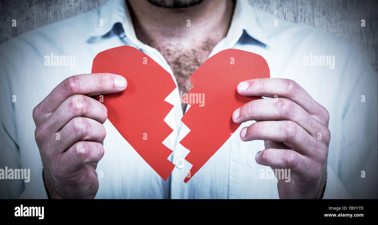 Composite image of sad man holding heart halves Stock Photo - Alamy