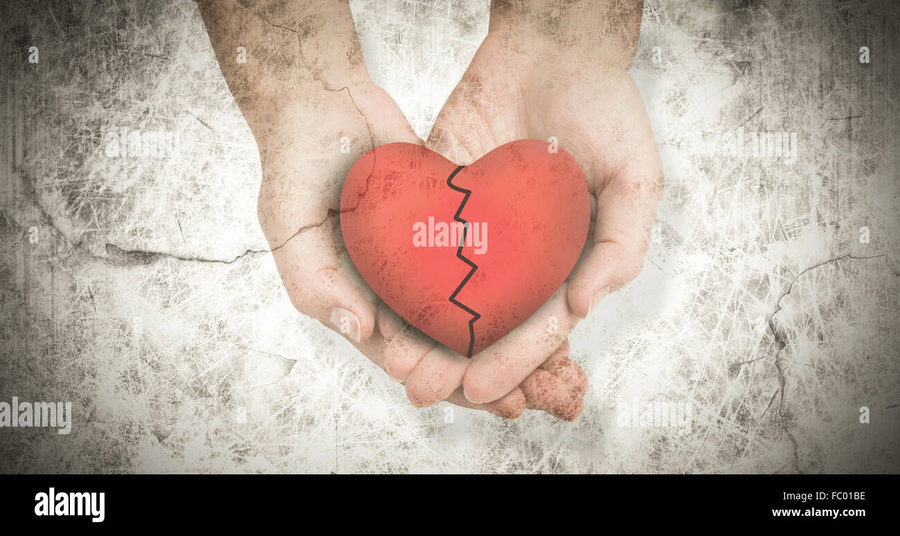 Composite image of couple holding broken heart in hands Stock Photo - Alamy