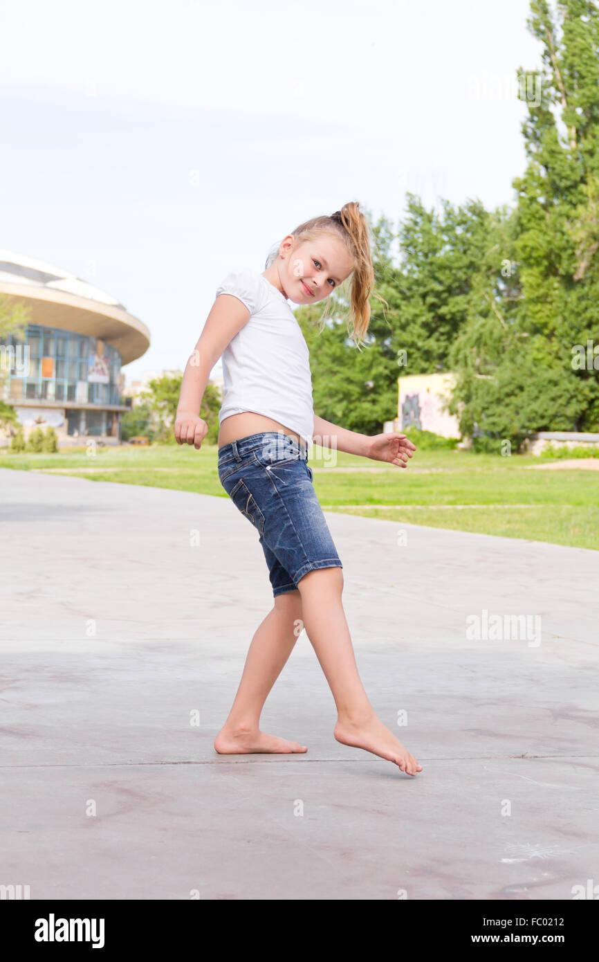 Cute girl jumping on one leg Stock Photo - Alamy