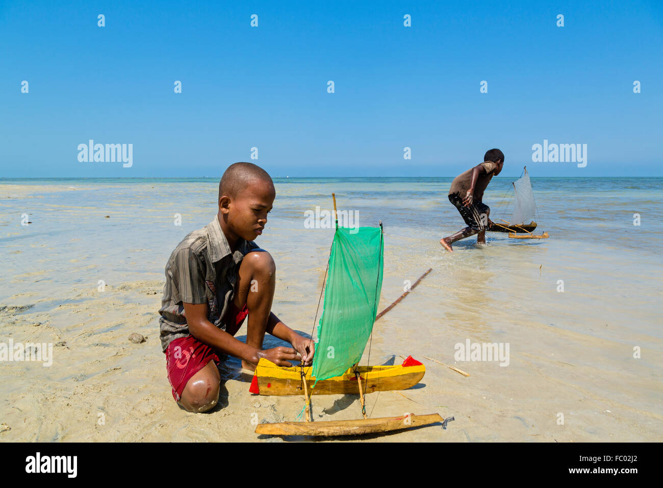 Young people playing with a pirogue model,Fishing harbour at Ifaty ...