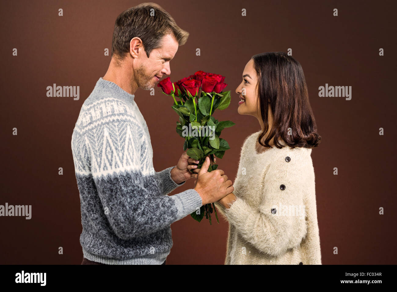Composite image of romantic couple holding red roses Stock Photo - Alamy