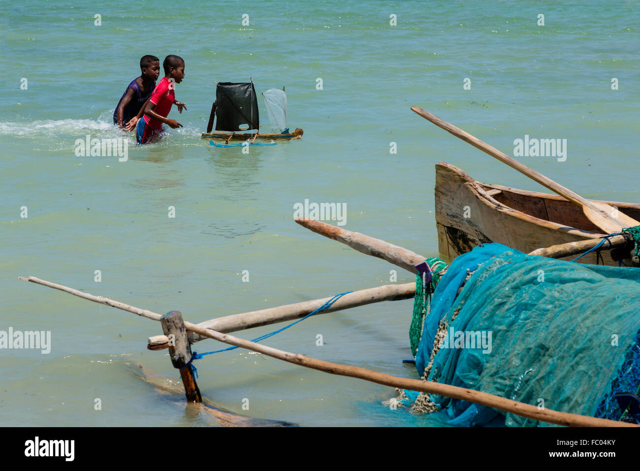 Young people playing with a pirogue model,Fishing harbour at Ifaty ...
