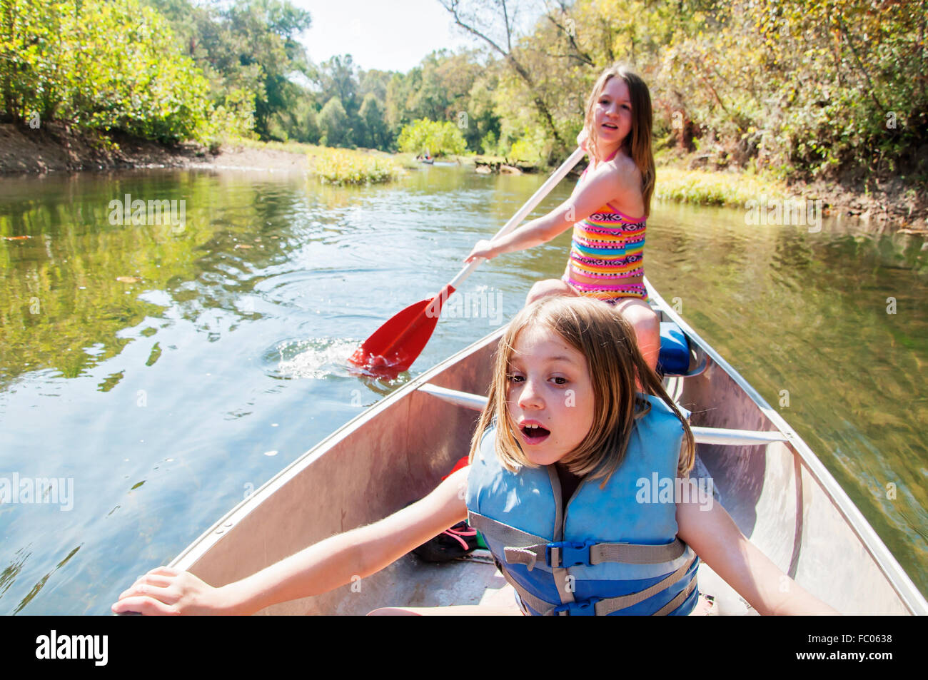 girls rowing canoe down river Stock Photo - Alamy