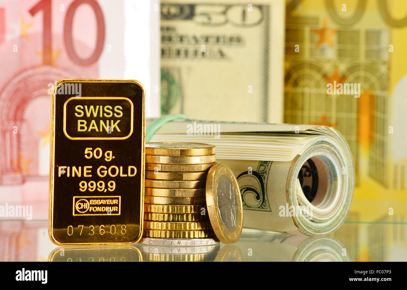Composition with 50 gram gold bar, banknotes and coins Stock Photo - Alamy