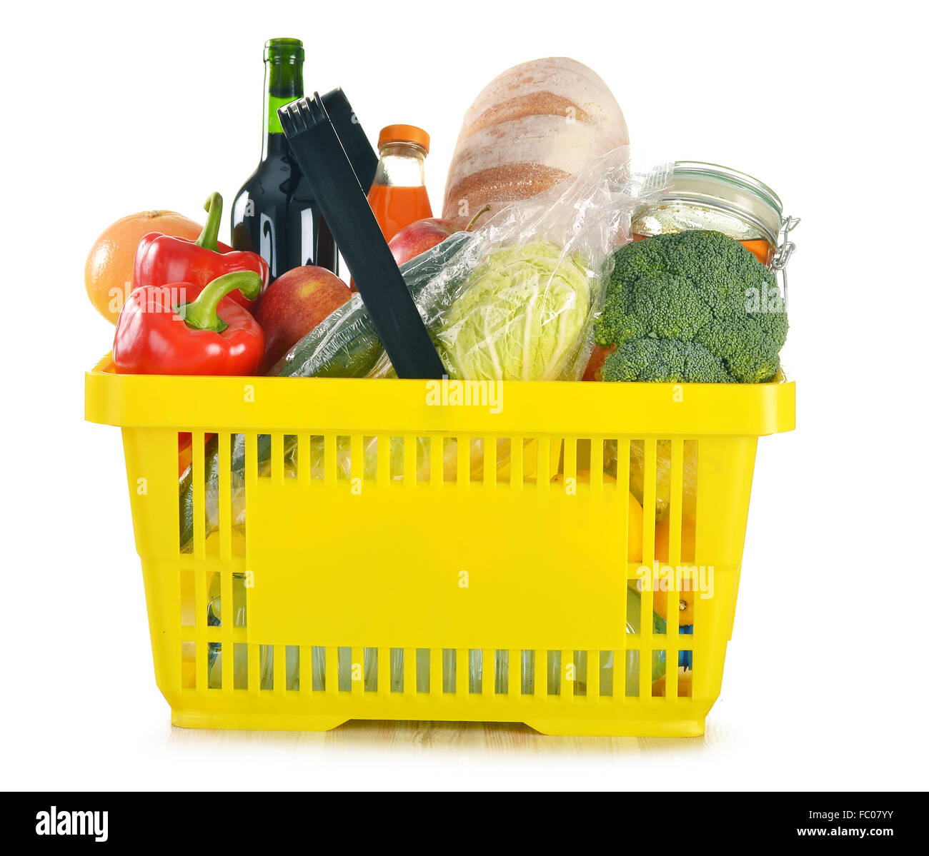 Yellow shopping basket with variety of grocery products including ...