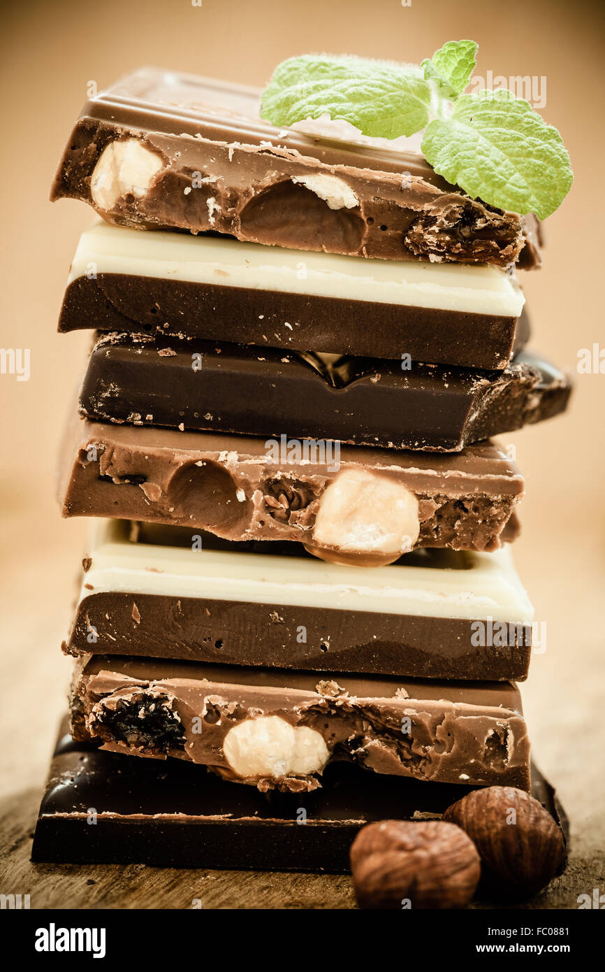 Stack of different sorts chocolate and hazelnuts Stock Photo - Alamy