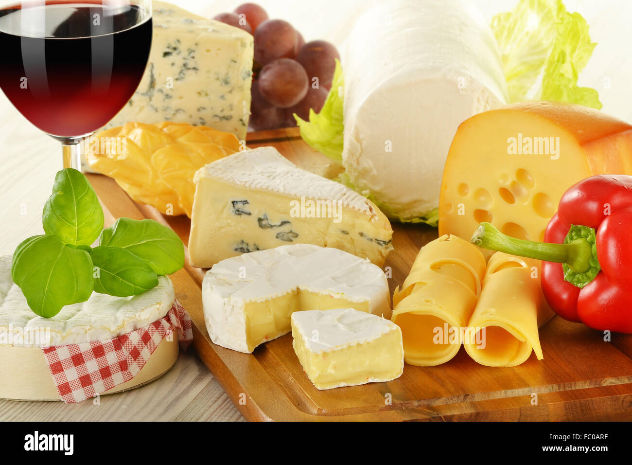 Composition with pieces of cheese on breadboard Stock Photo - Alamy