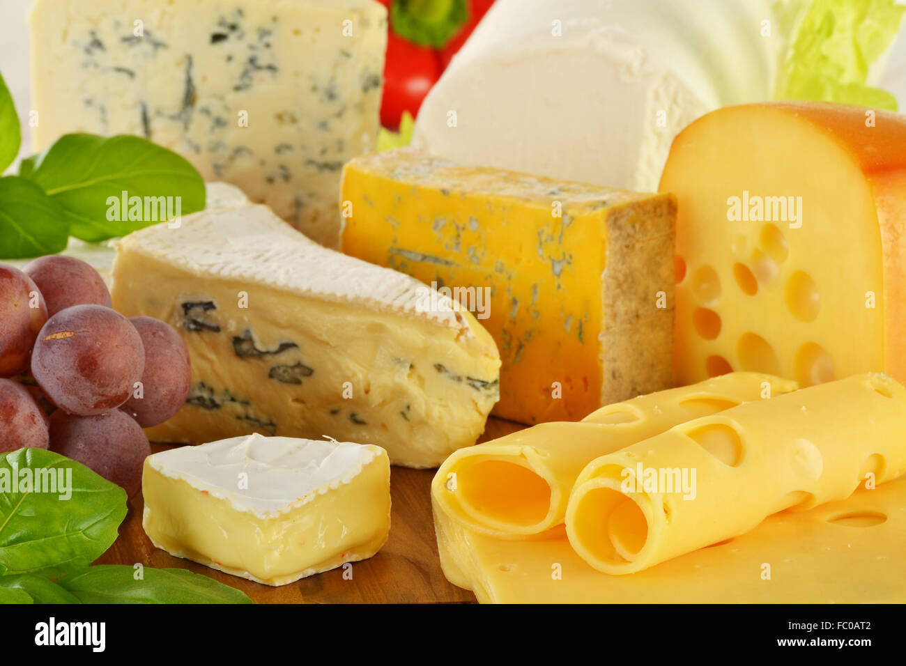 Composition with pieces of cheese on breadboard Stock Photo - Alamy