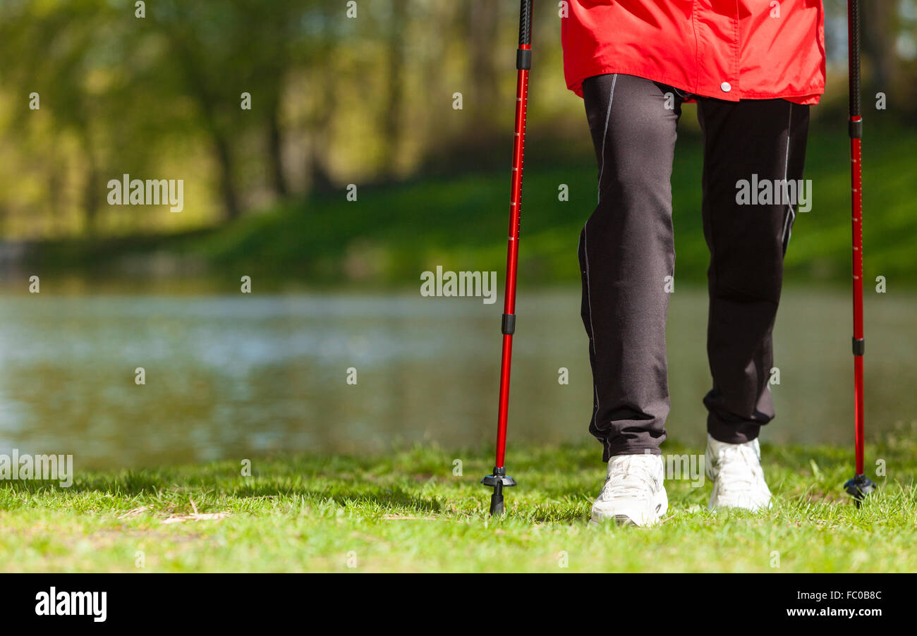 Nordic walking. Female legs hiking in the park Stock Photo - Alamy