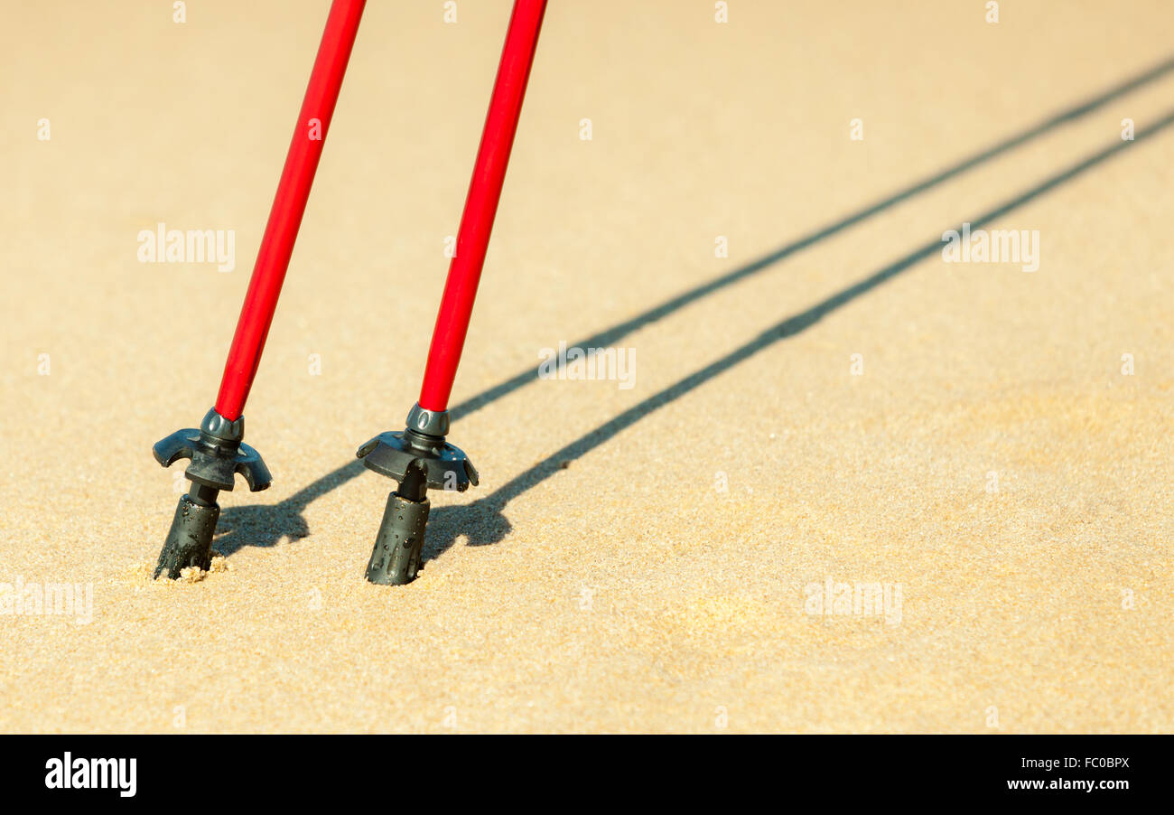 Nordic walking. Red sticks on the sandy beach Stock Photo - Alamy