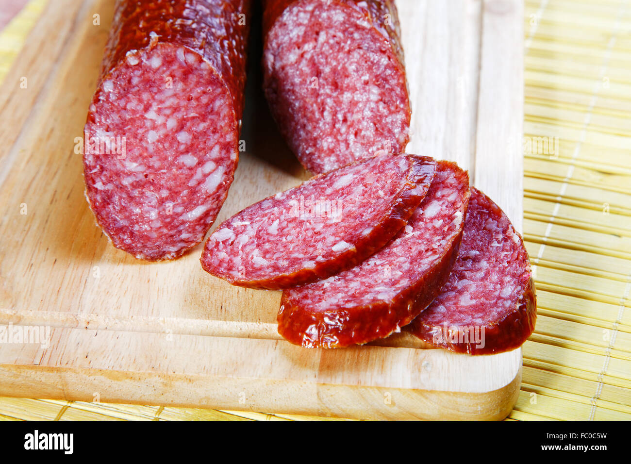 The cut smoked sausage on a wooden board Stock Photo - Alamy